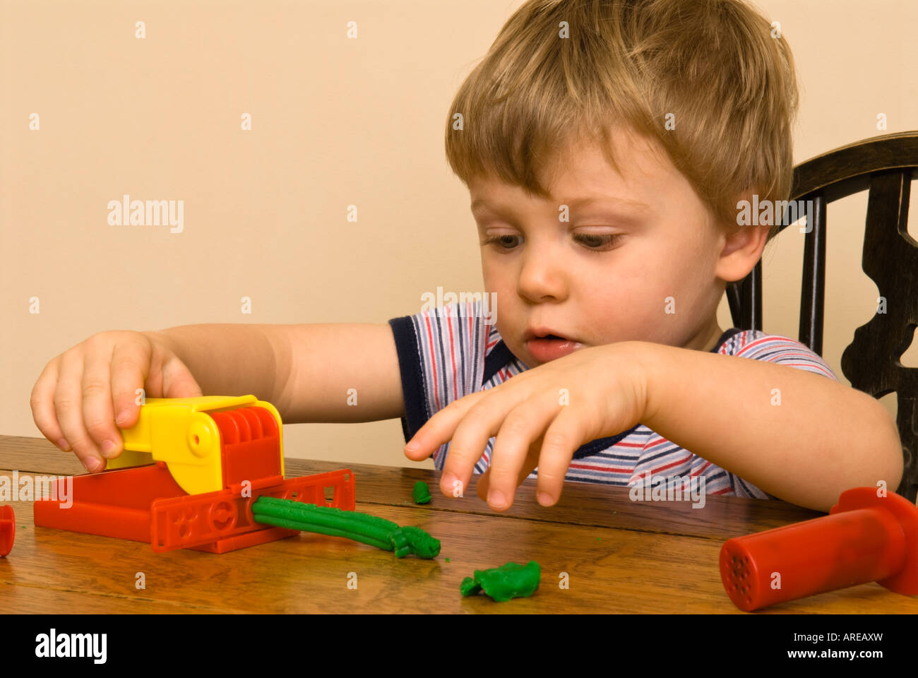 boy toddler child playing with 'Play Dough' tools and toys cutting and ...