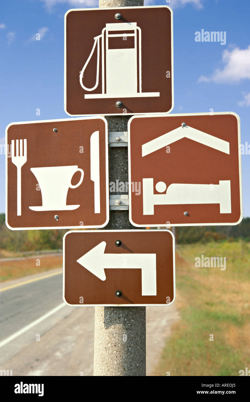 Group road signs beside indicating there is gas food and lodging ahead ...