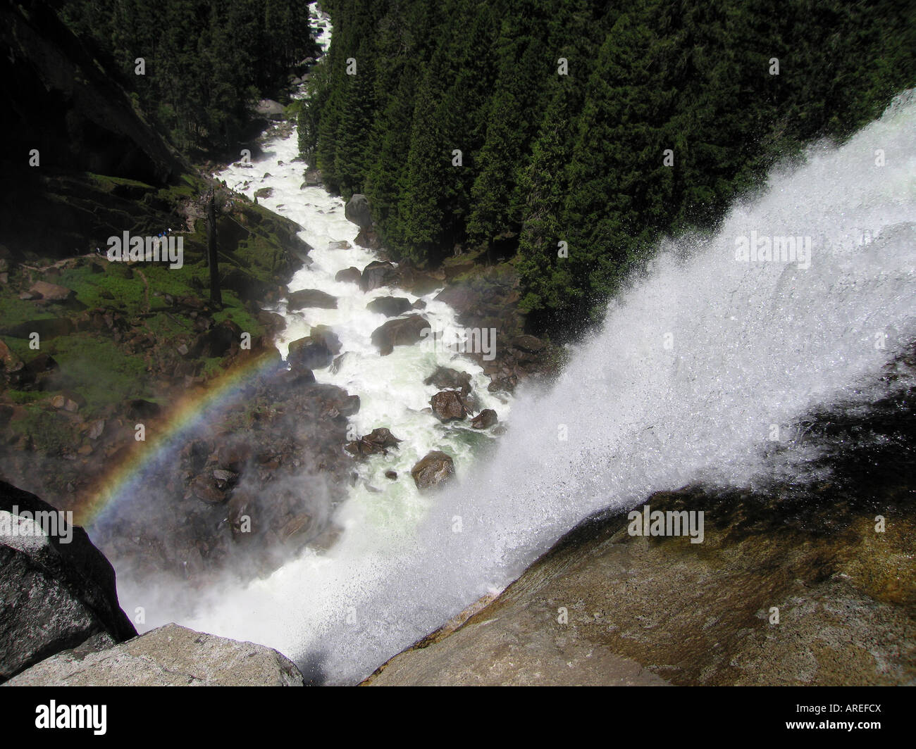 Rainbow over waterfall crashing onto rocks below, Yosemite San ...