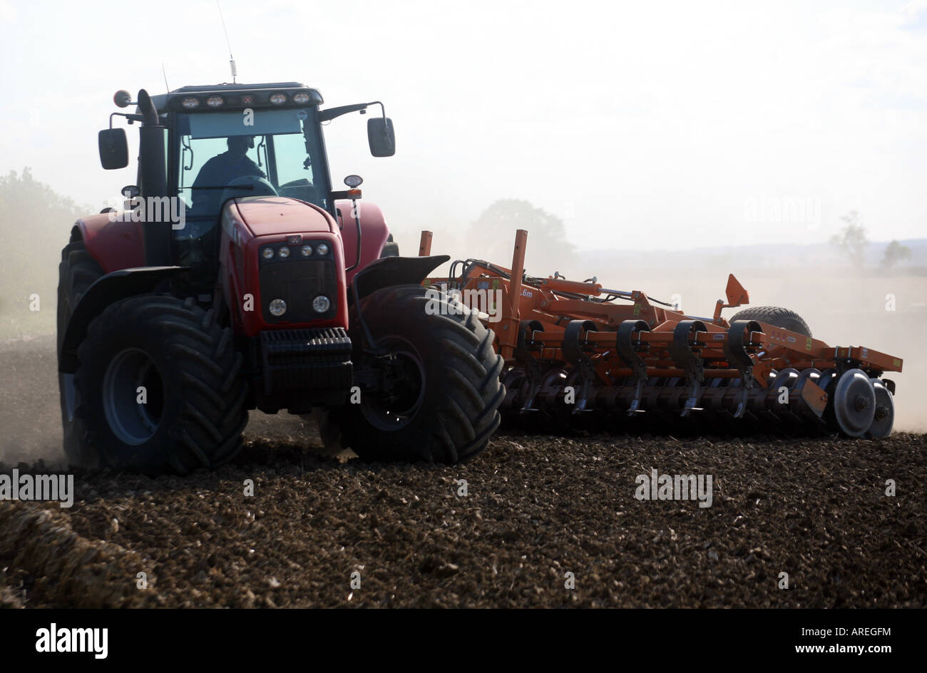 A tractor rolling fields in Cowlinge near Haverhill Suffolk Stock Photo ...