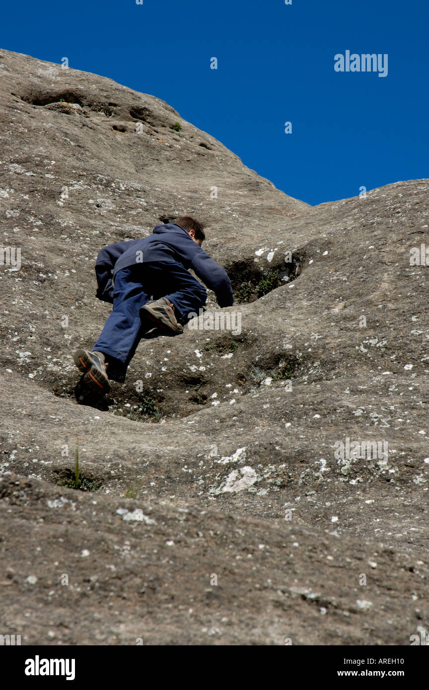 Young boy climbing a rock Stock Photo - Alamy