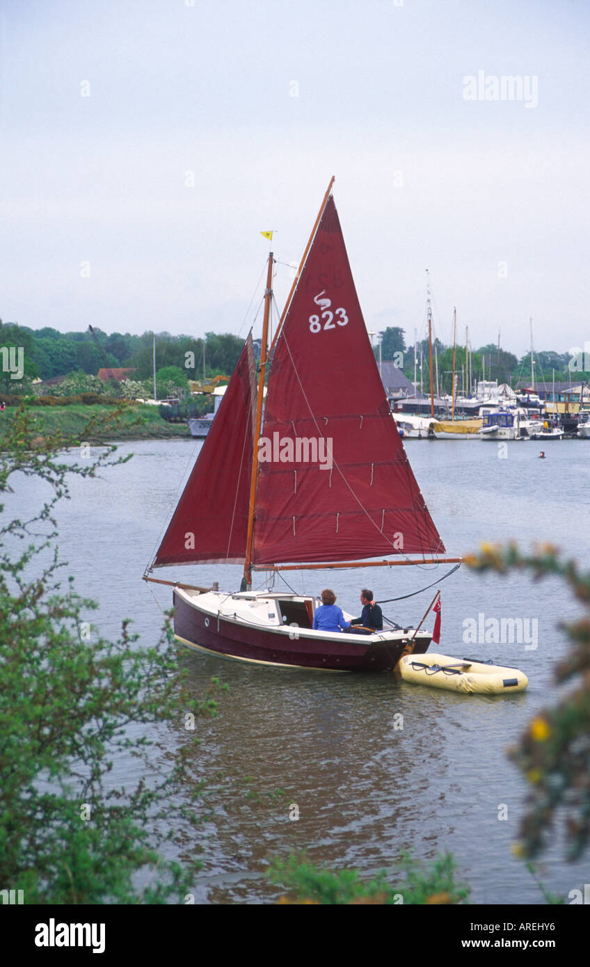 Small sailing boat with red sail River Deben, Melton, Suffolk, England ...