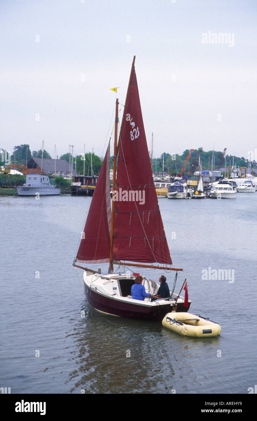 Small sailing boat with red sail River Deben, Melton, Suffolk, England ...