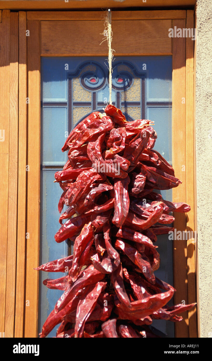 Santa Fe New Mexico red chillies cluster or ristras in front of stained ...