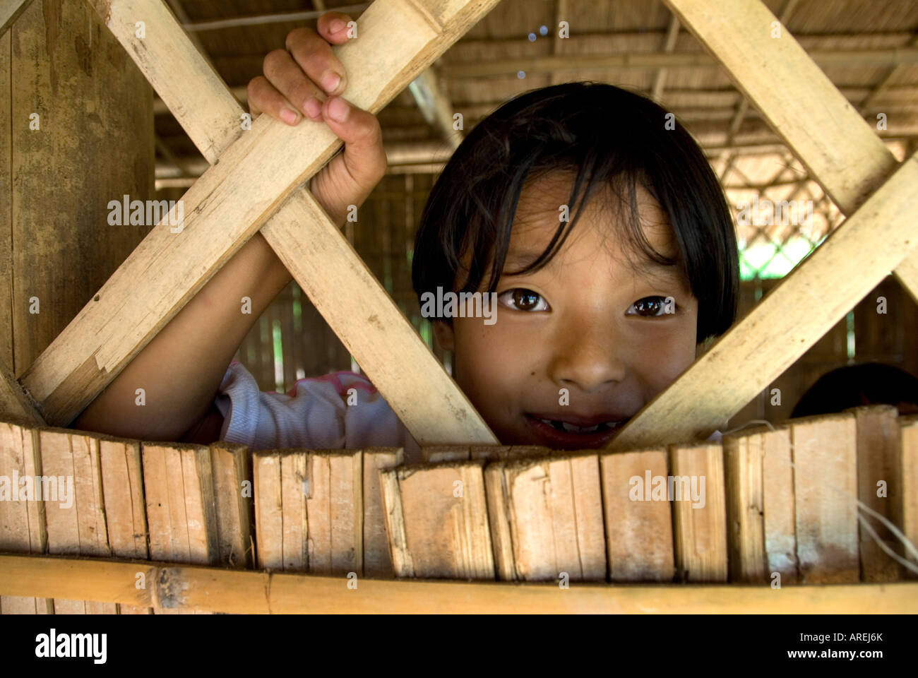 Hill tribe children looking out of a simple bamboo church in a village ...