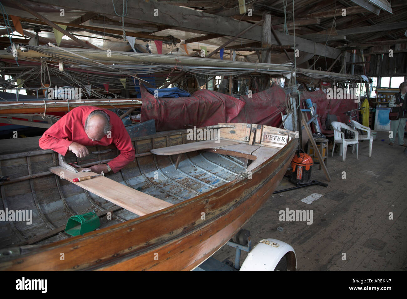 Man repairing a small wooden boat in traditional boatyard hi-res stock ...