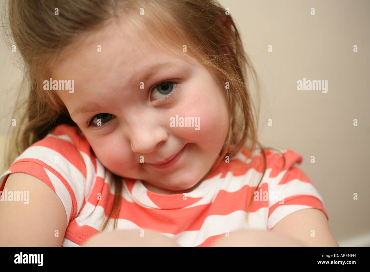 5 year old girl in a red and white T-shirt smiling and looking cheeky ...