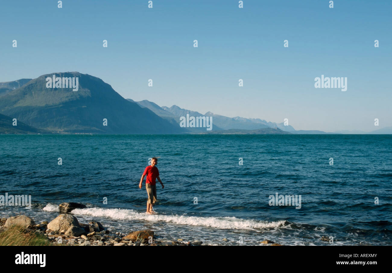 Man walking bare feet in cold water of the Arctic Ocean, Skibotn ...