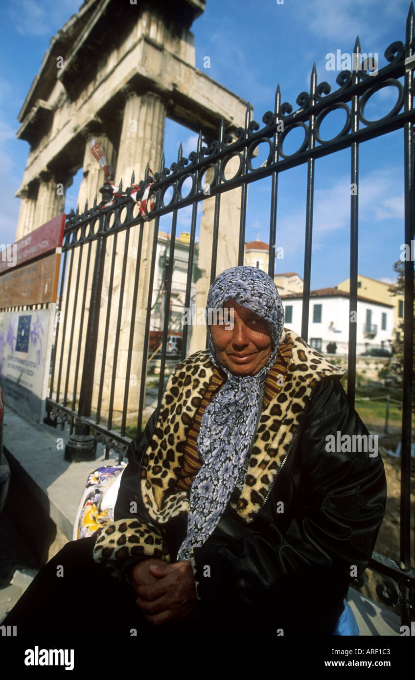 Gypsy woman selling trinkets ancient ruin in background in Monastiraki ...