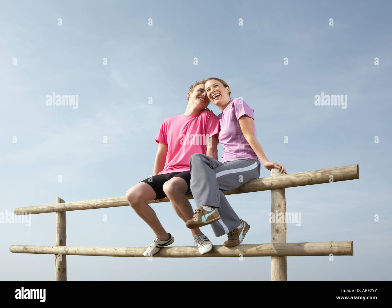 A Young couple sit on a country fence Stock Photo - Alamy