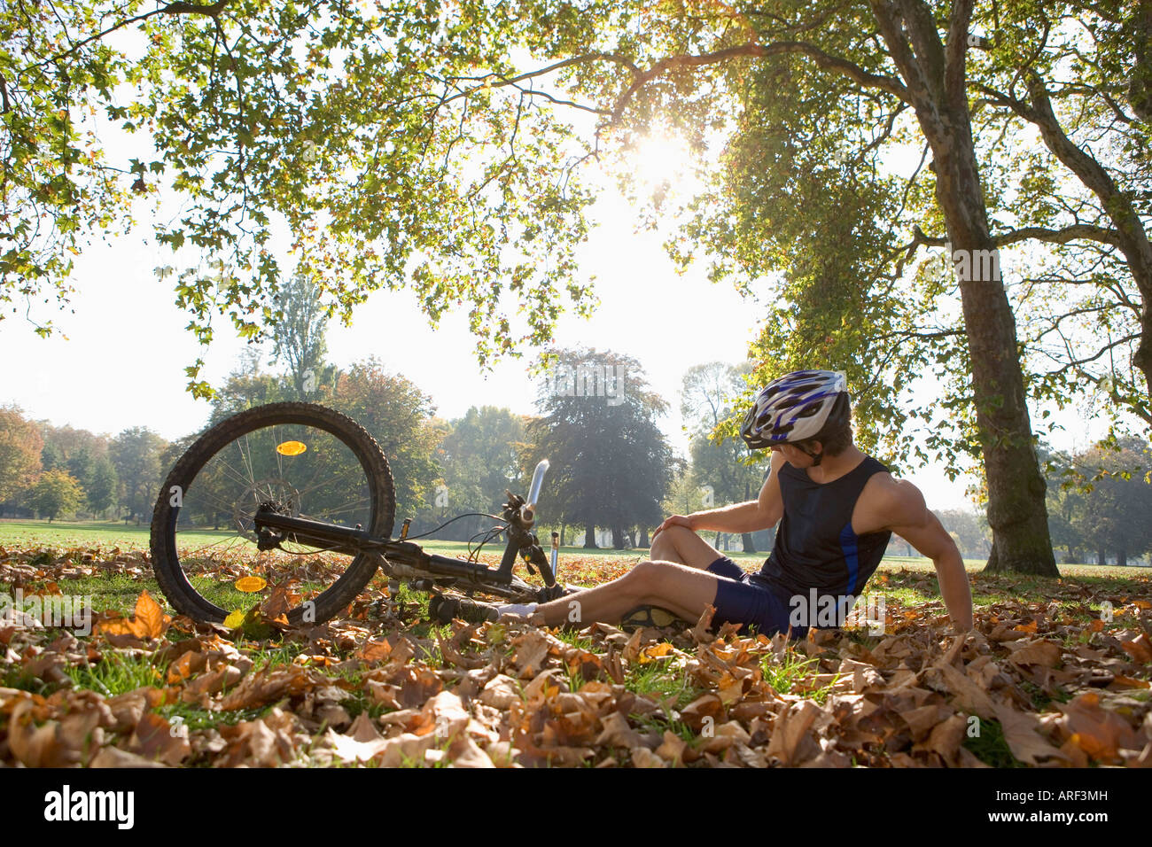 Cyclists looking at injury Stock Photo - Alamy