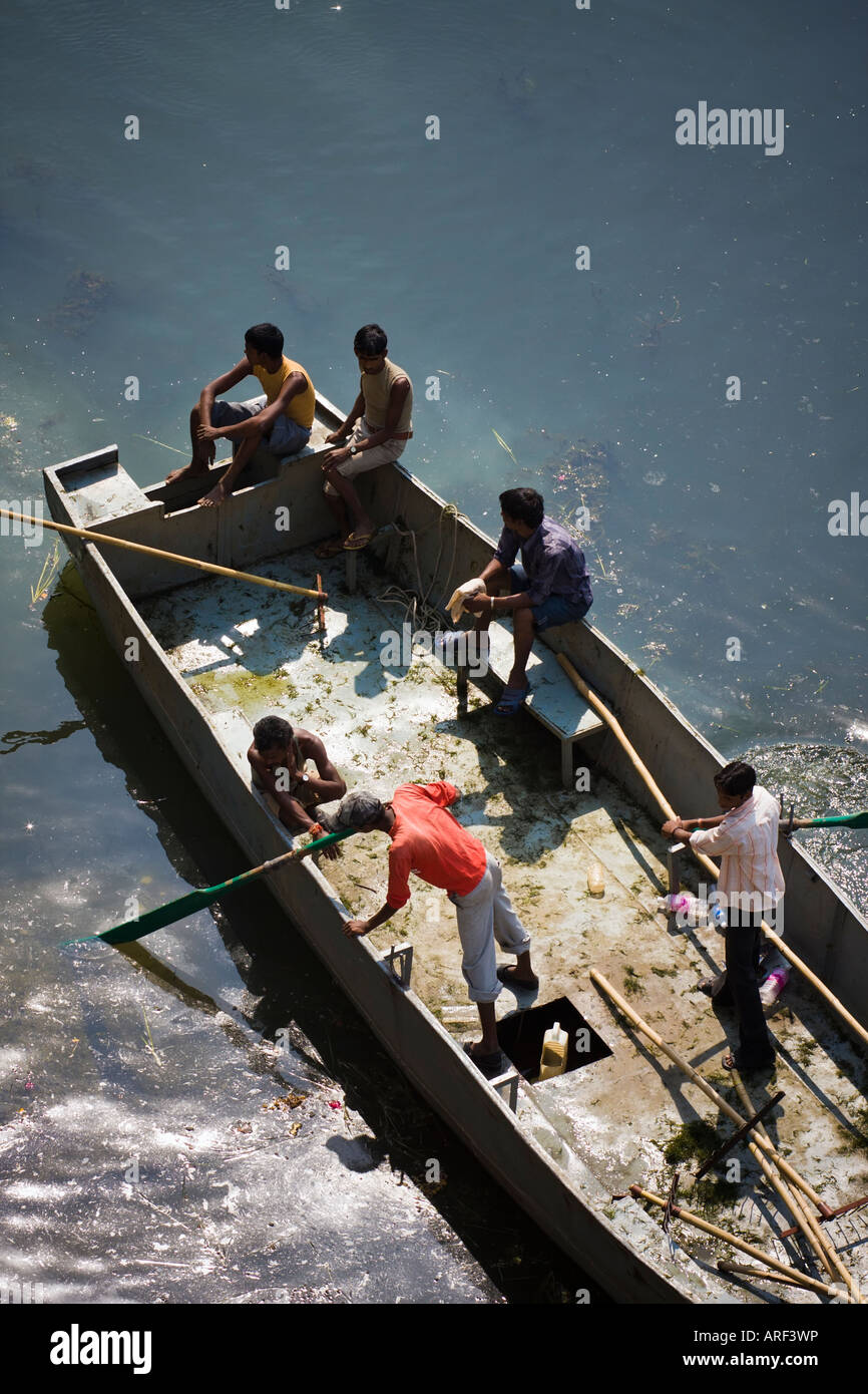 Indian men on a boat cleaning Pichola lake - Udaipur, Rajasthan, India ...