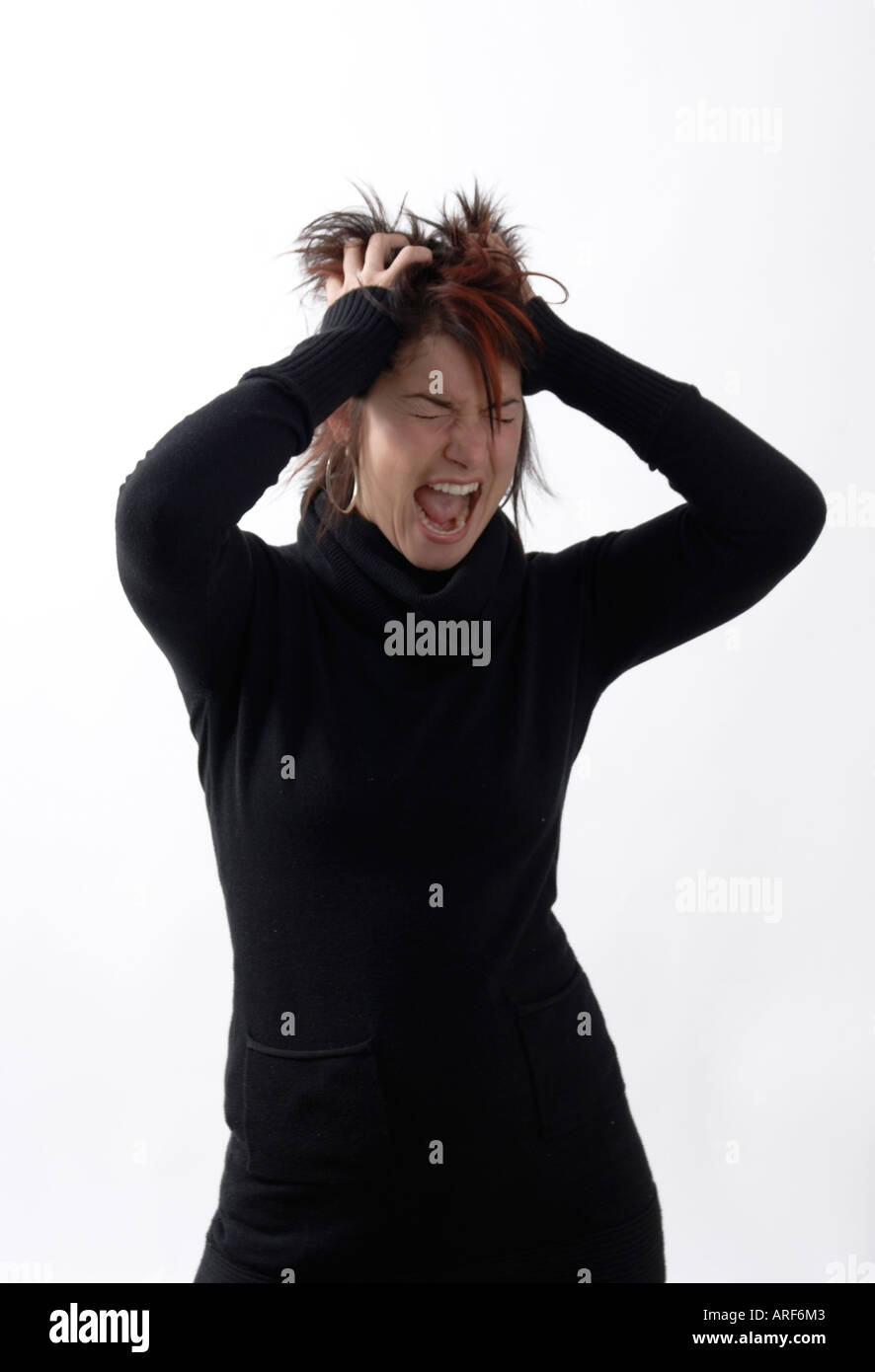 Woman in black really stressed - tearing hair out Stock Photo - Alamy