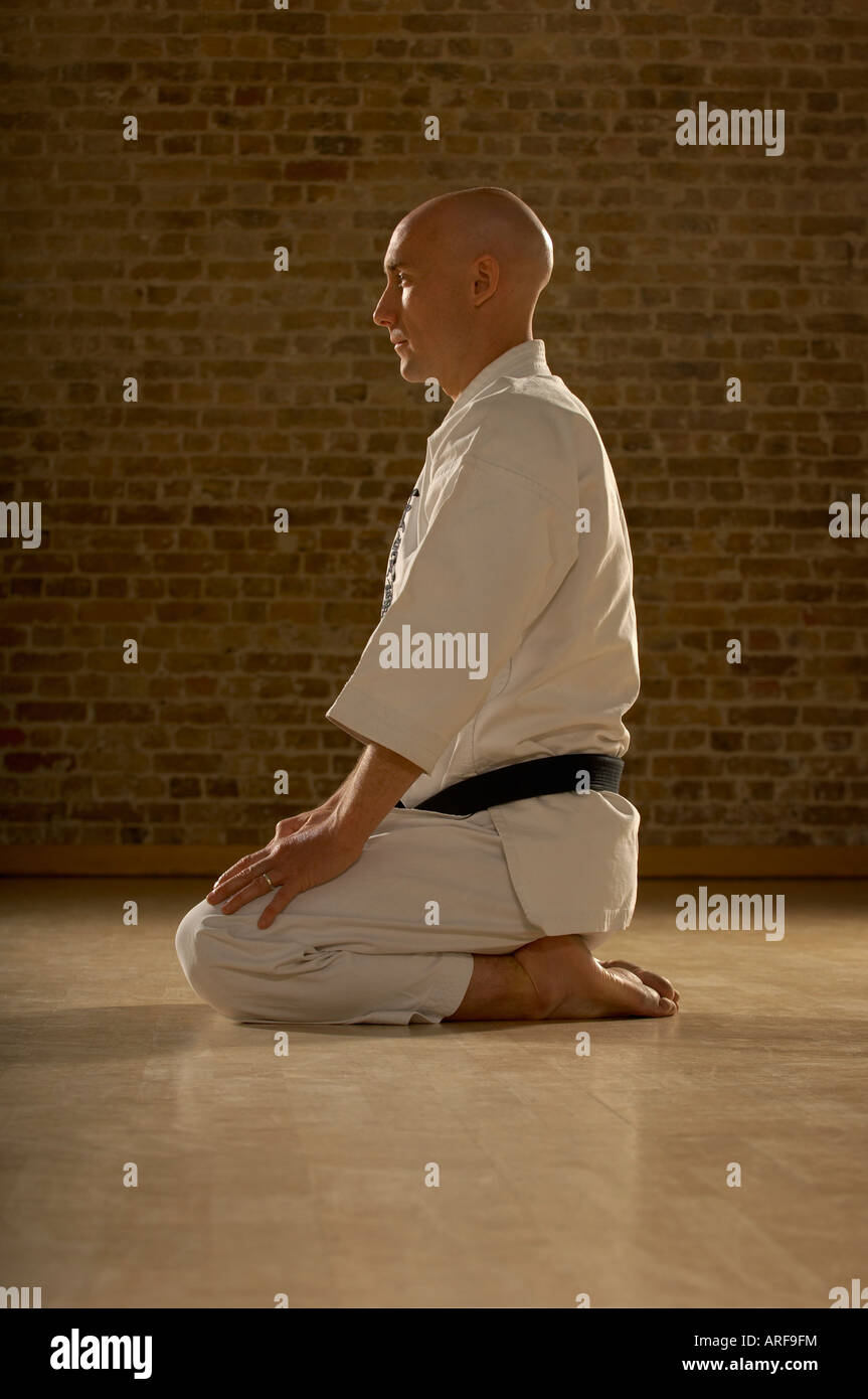 Karate man kneeling Stock Photo - Alamy