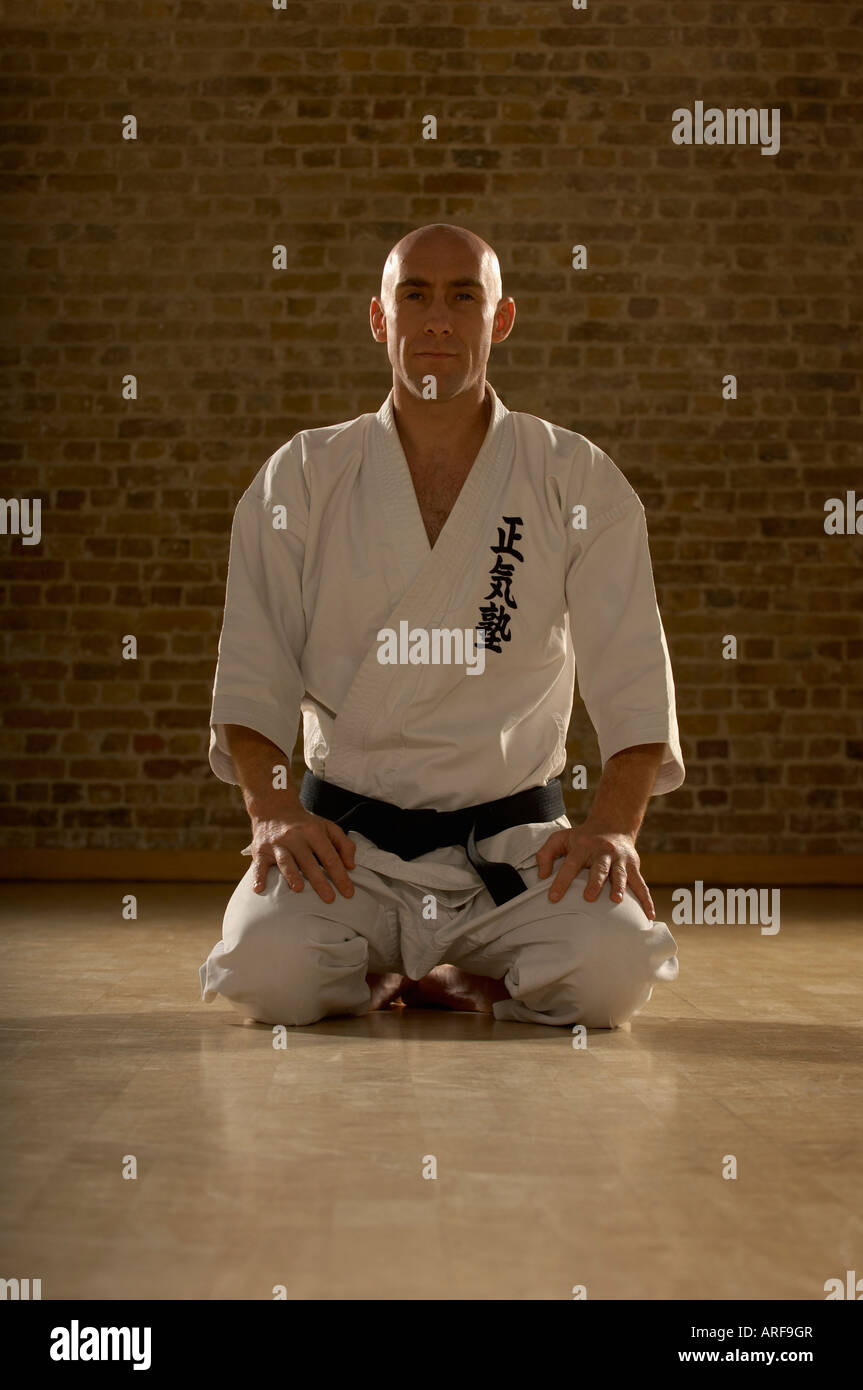 Karate man kneeling Stock Photo - Alamy