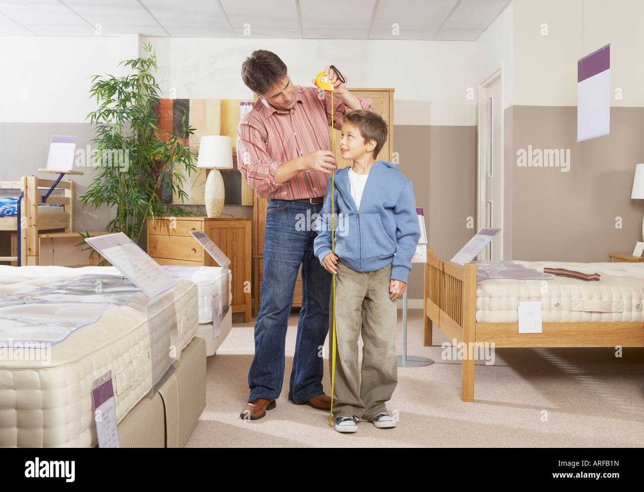 Man measuring boy with tape measure Stock Photo - Alamy