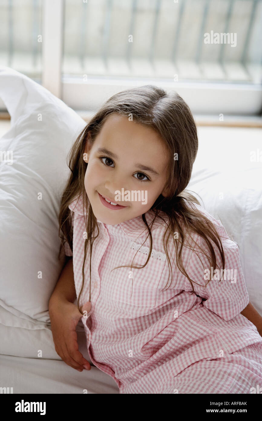 Portrait of a young girl laying on a bed Stock Photo - Alamy