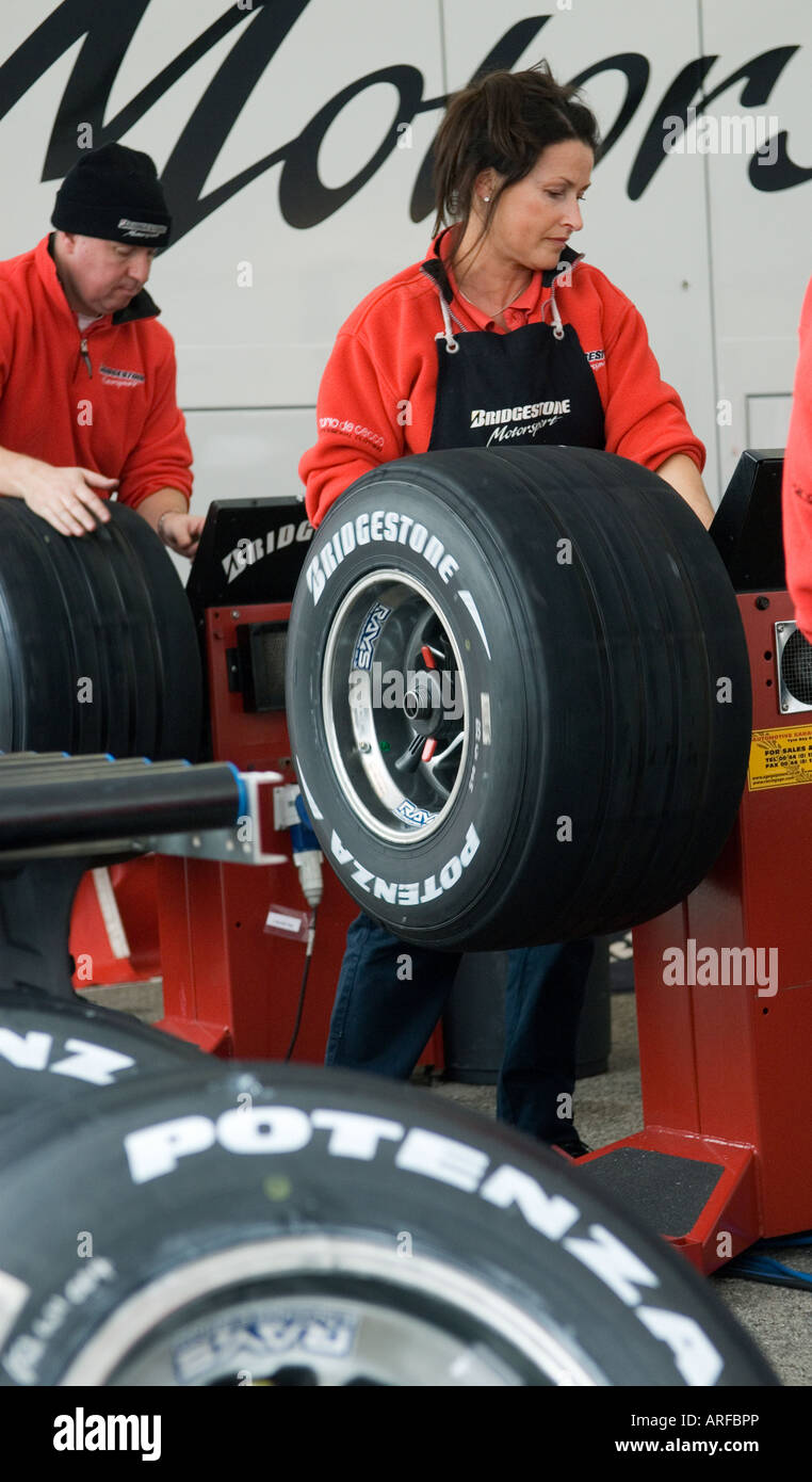 female Bridgestone technician works on tire during Formula 1 Testing on ...