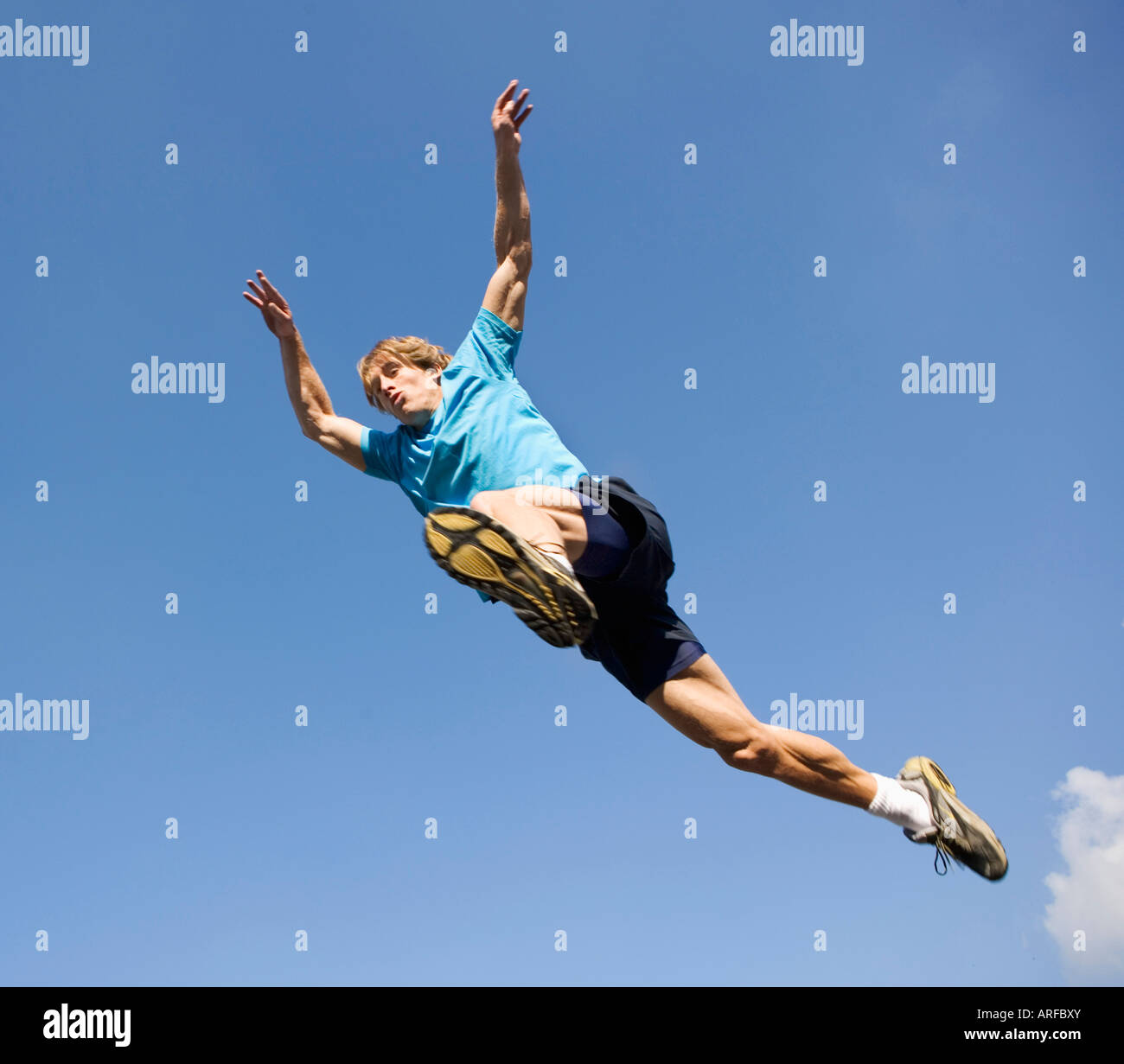 Young man jumping in sports kit Stock Photo - Alamy
