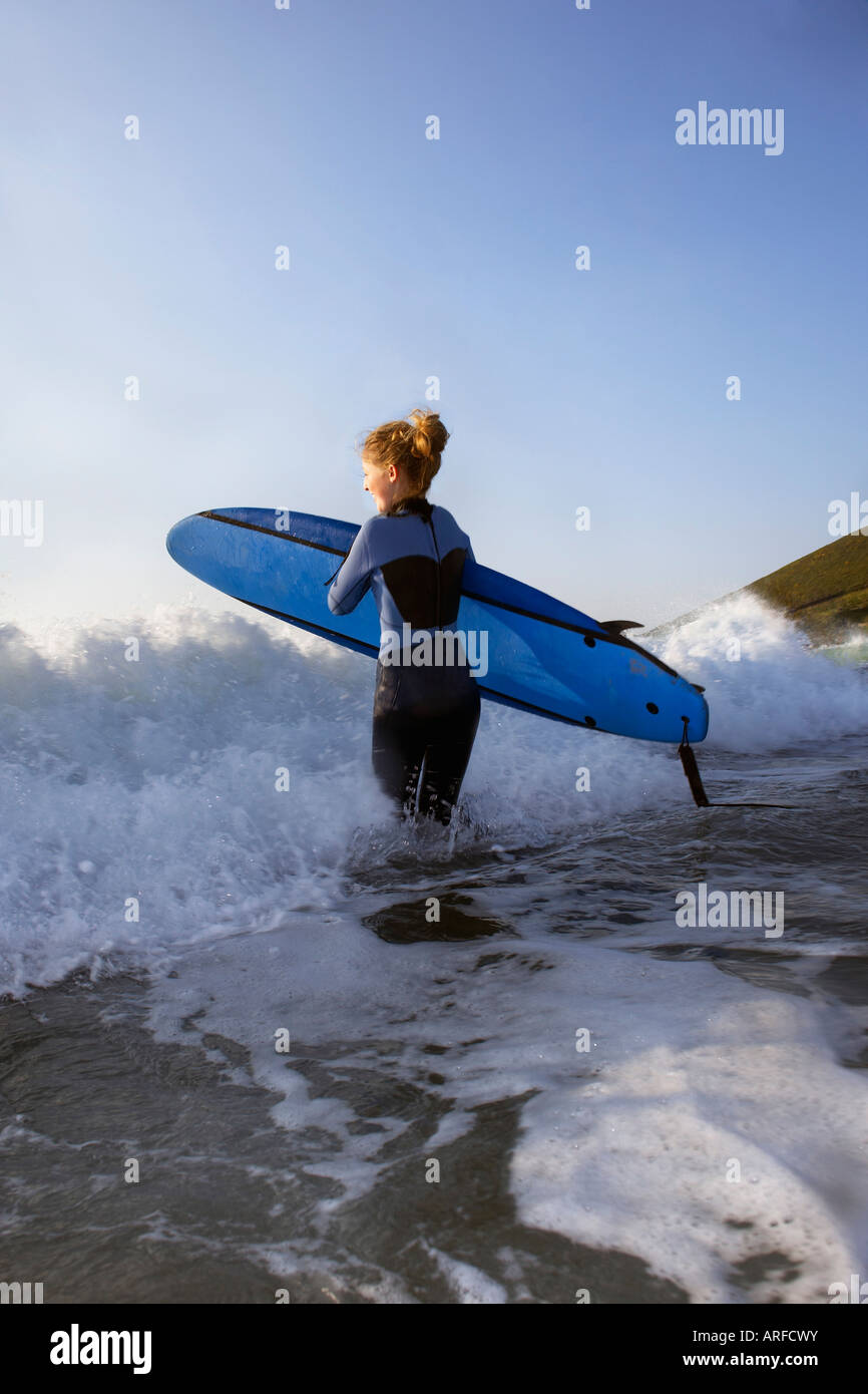 Female surfer running into the surf Stock Photo - Alamy