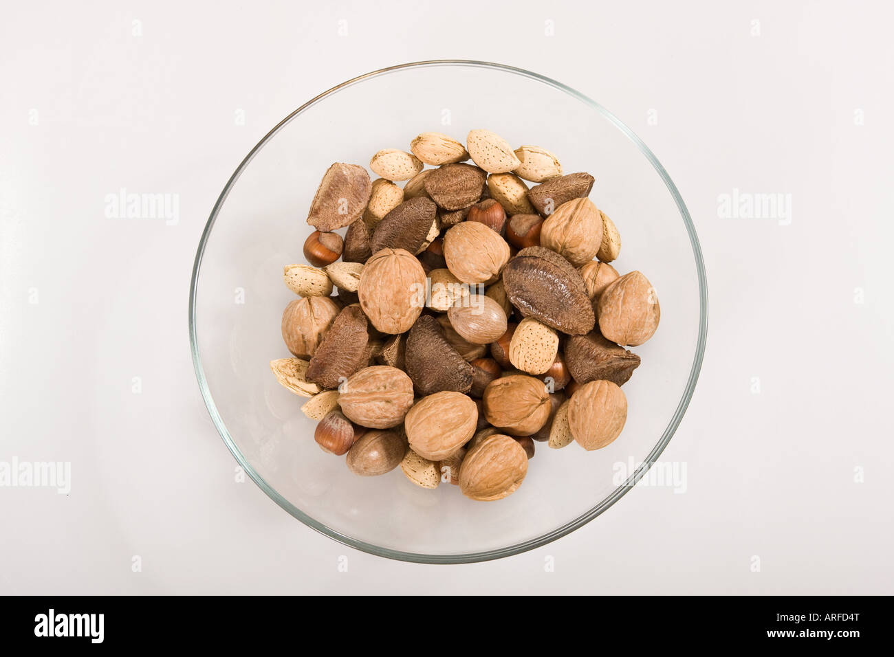 Various kinds of nuts in shells in the glass bowl from above overhead ...