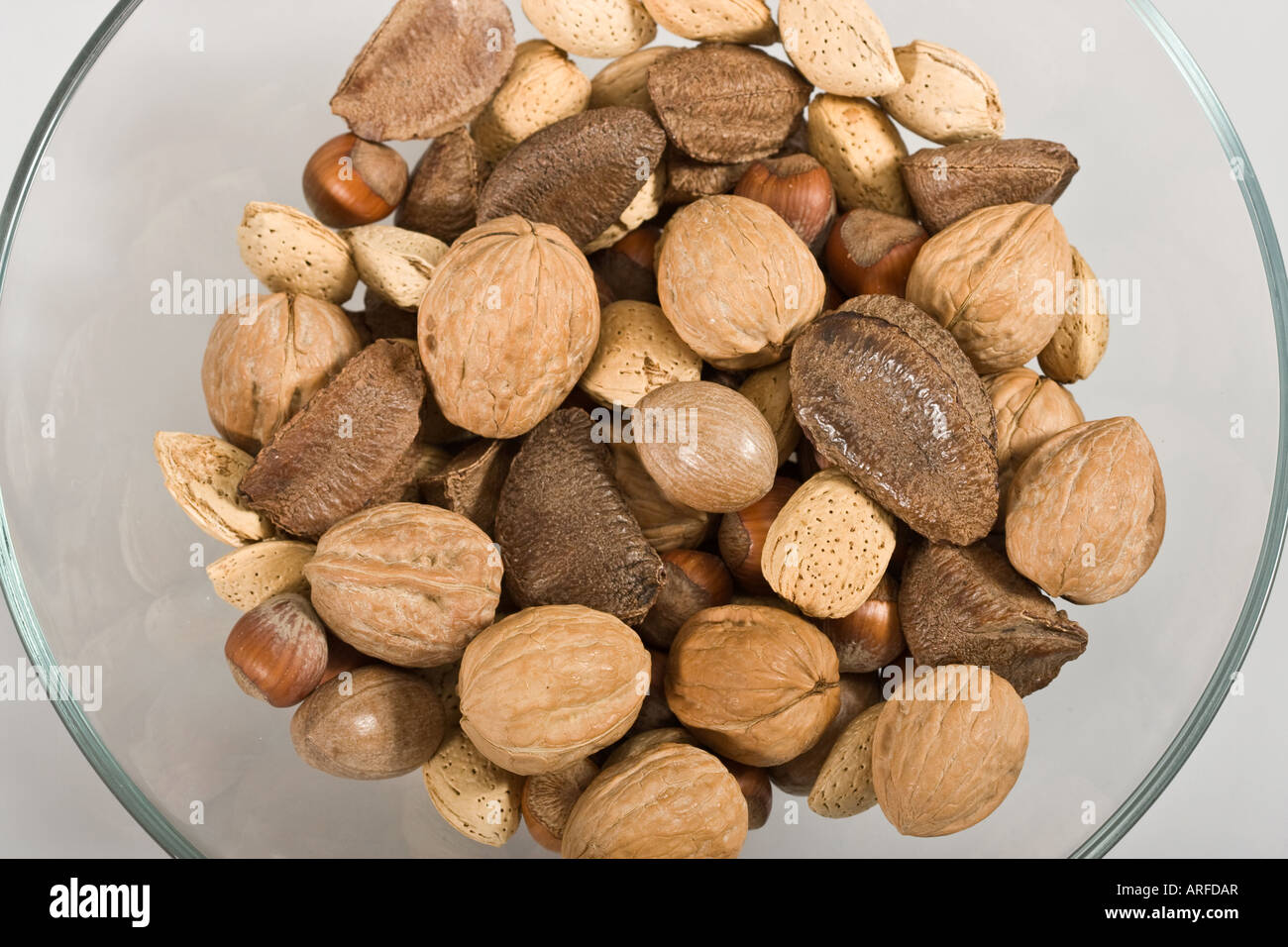 Various kinds of nuts in shells in the glass bowl from above overhead ...