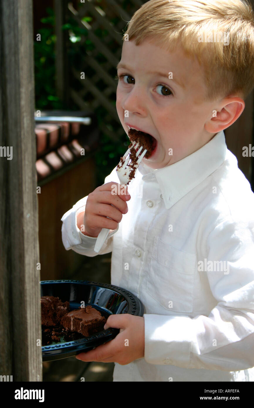 Boy eating chocolate cake Stock Photo - Alamy