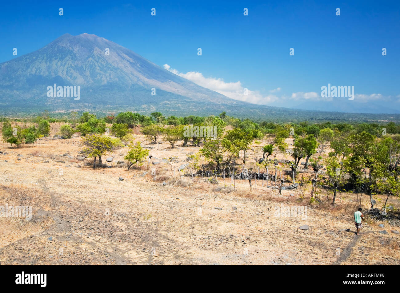 Solitary man walking by the foot of a Balinese volcano, Indonesia Stock ...