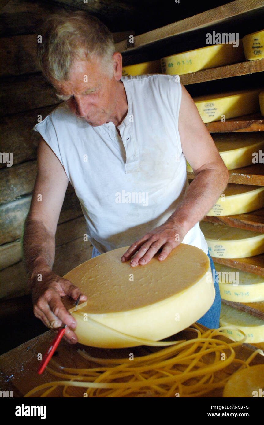 Trimming the edge of the rind forming on a Alp cheese Stock Photo - Alamy