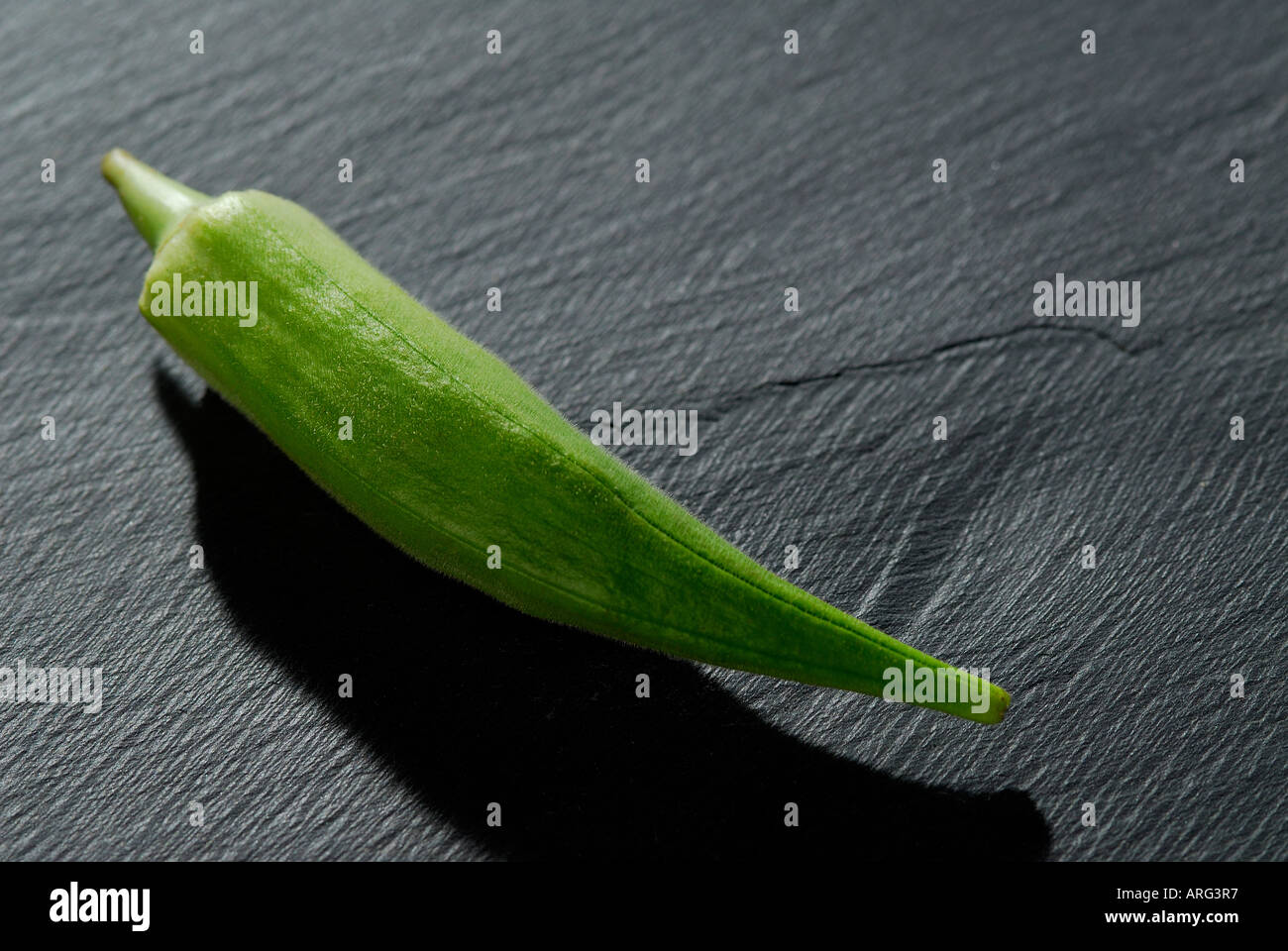 single okra on black slate worktop Stock Photo - Alamy