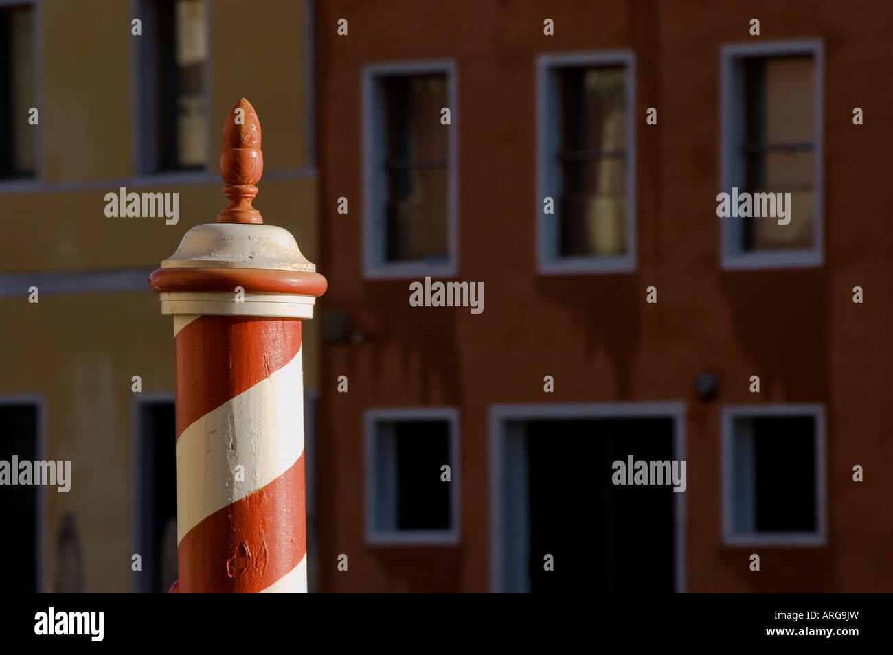 Detail of a typical white and red wooden pole in a canal of Venice ...