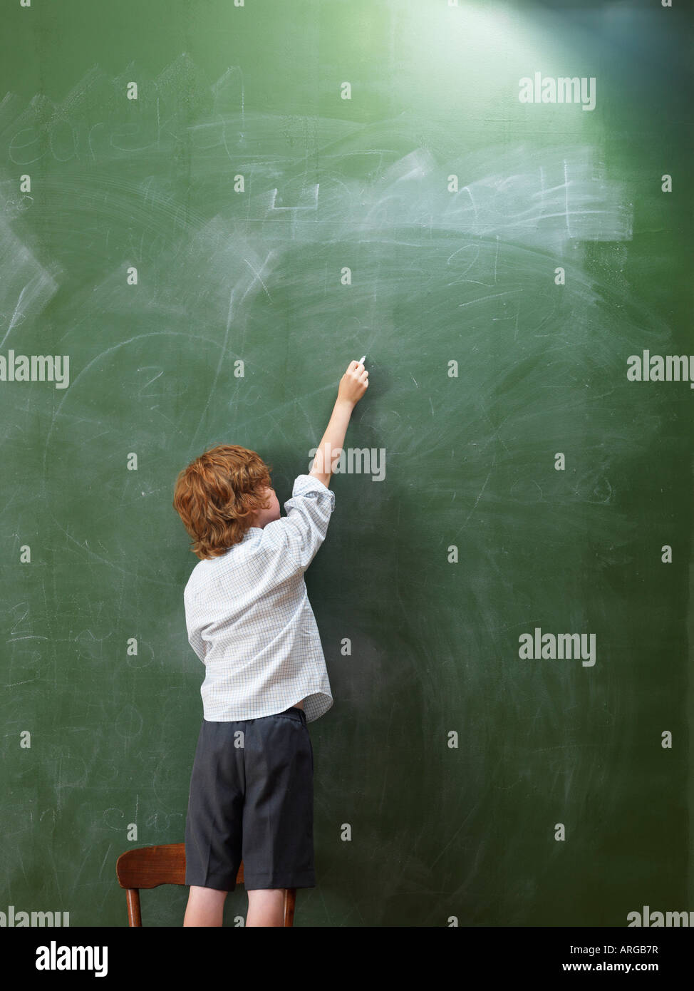 Boy Writing on Blackboard Stock Photo - Alamy