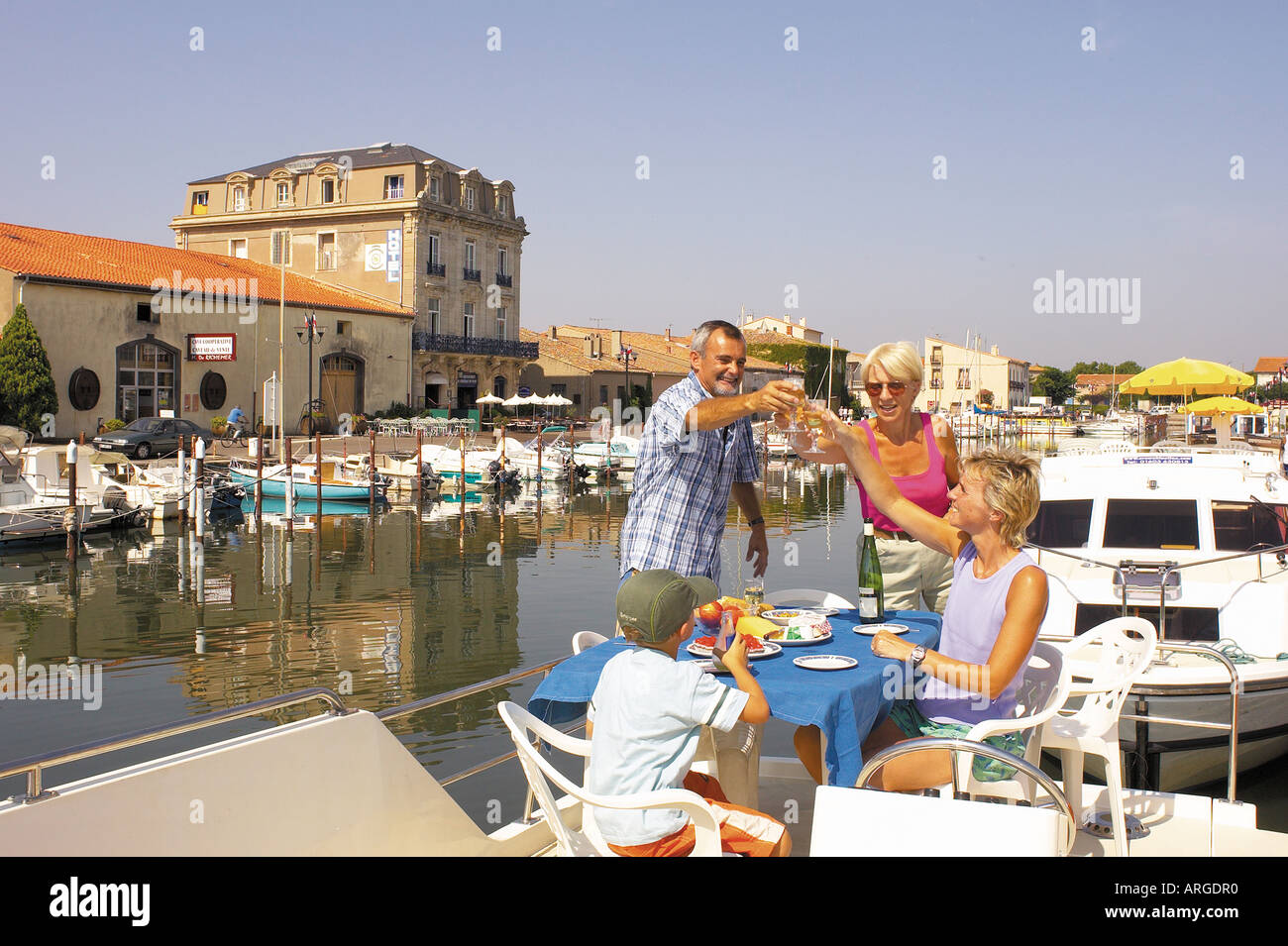 FAMILY CELEBRATE ON THE DECK OF A BOAT MOORED IN THE FRENCH HARBOUR OF ...
