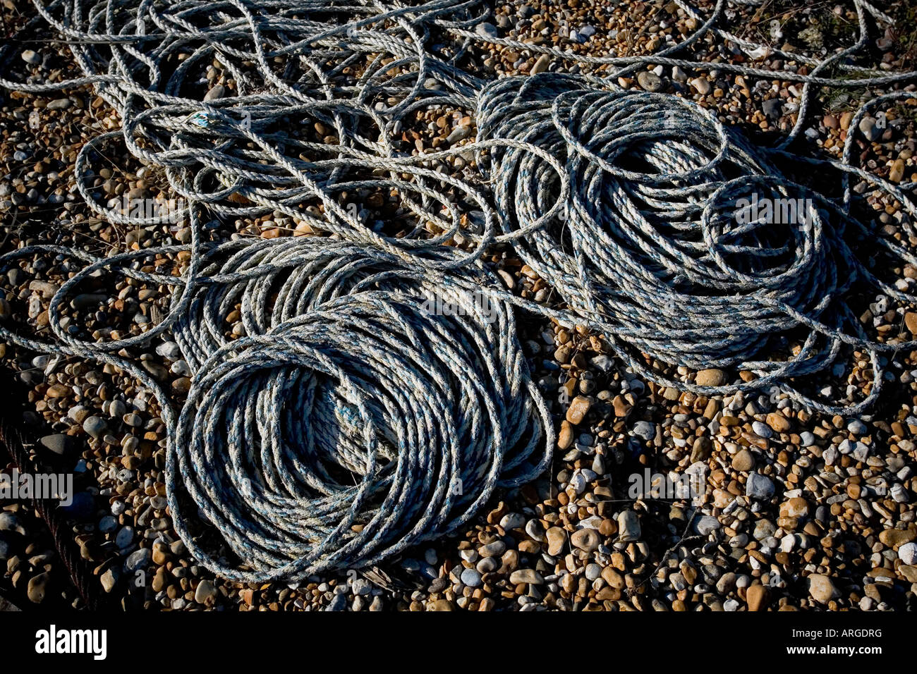 Coils of rope on shingle beach Stock Photo - Alamy