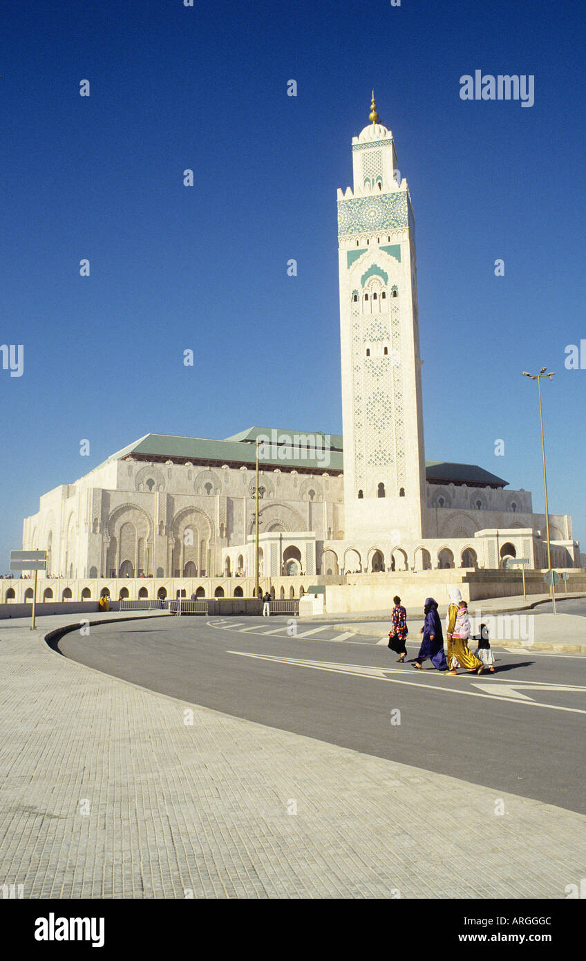 A Muslim family crossing the road in front of the structure and minaret ...