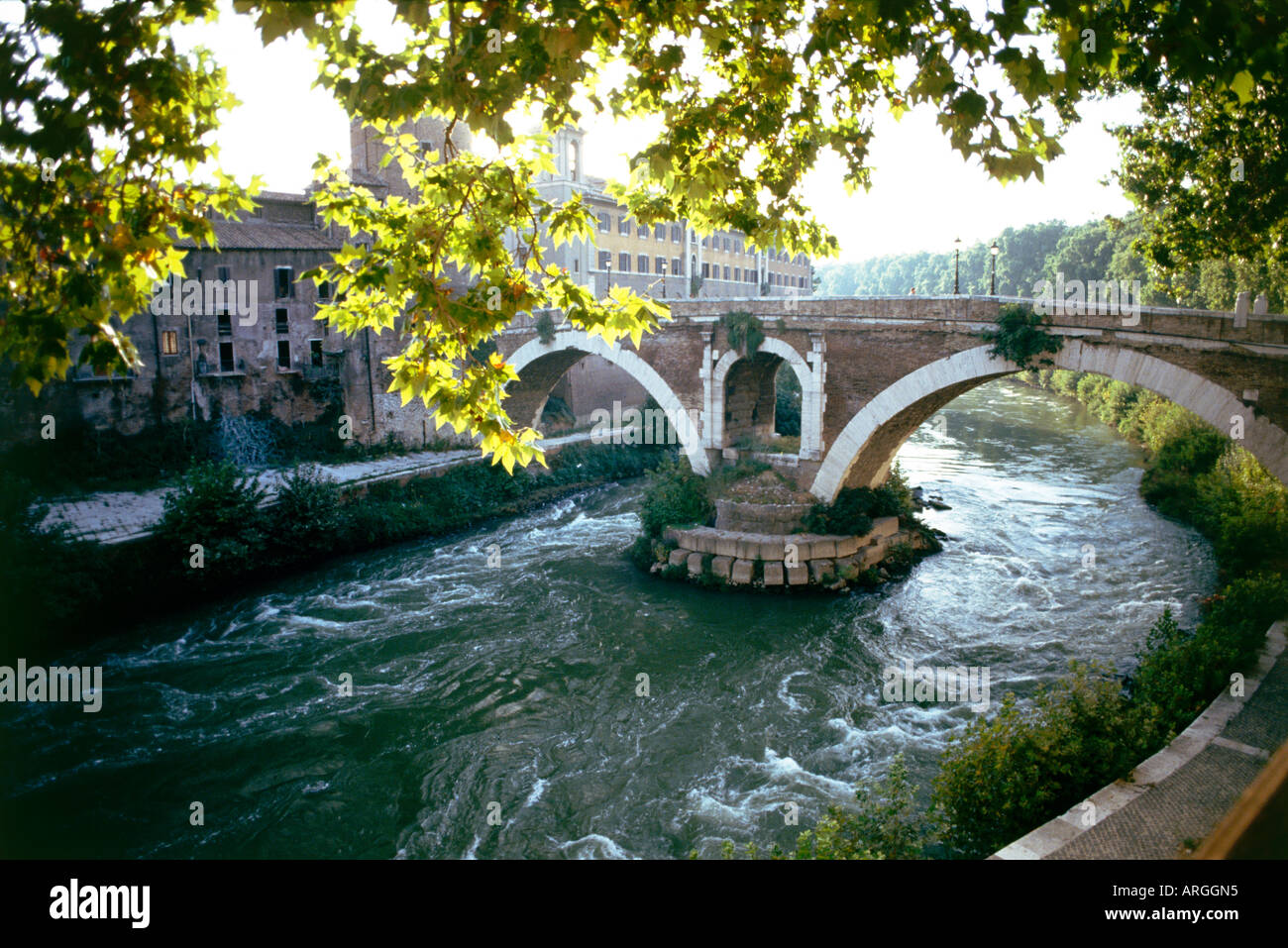 Framed by overhanging branches of tall trees one of the ancient bridges ...