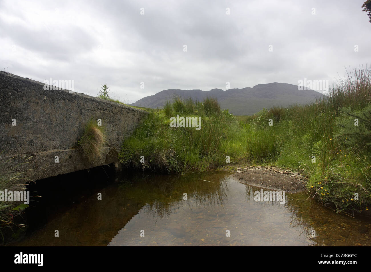 concrete culvert diverting stream under a country road in Connemara ...