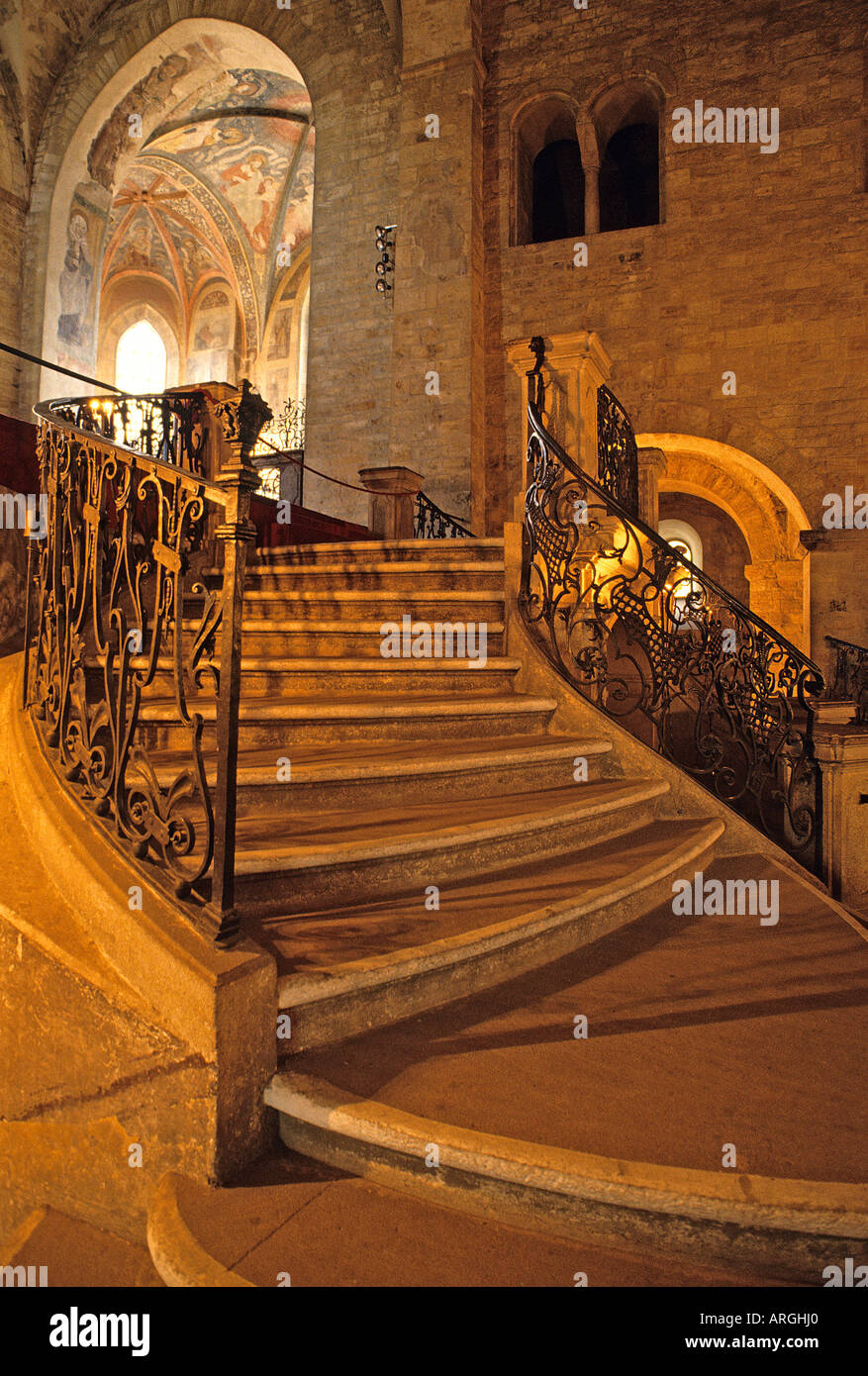 Ornate wrought iron railings line the curving staircase in the ...