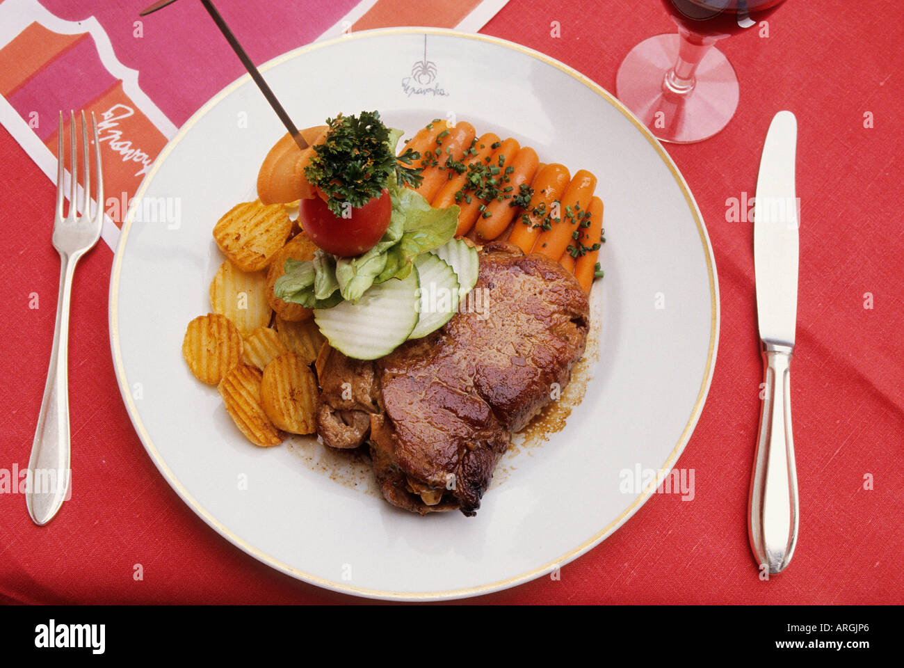 A plate of rolled beef in port roast potatoes and carrots garnished ...