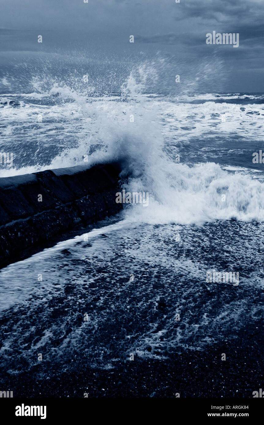 Wave crashing over a breakwater Stock Photo - Alamy