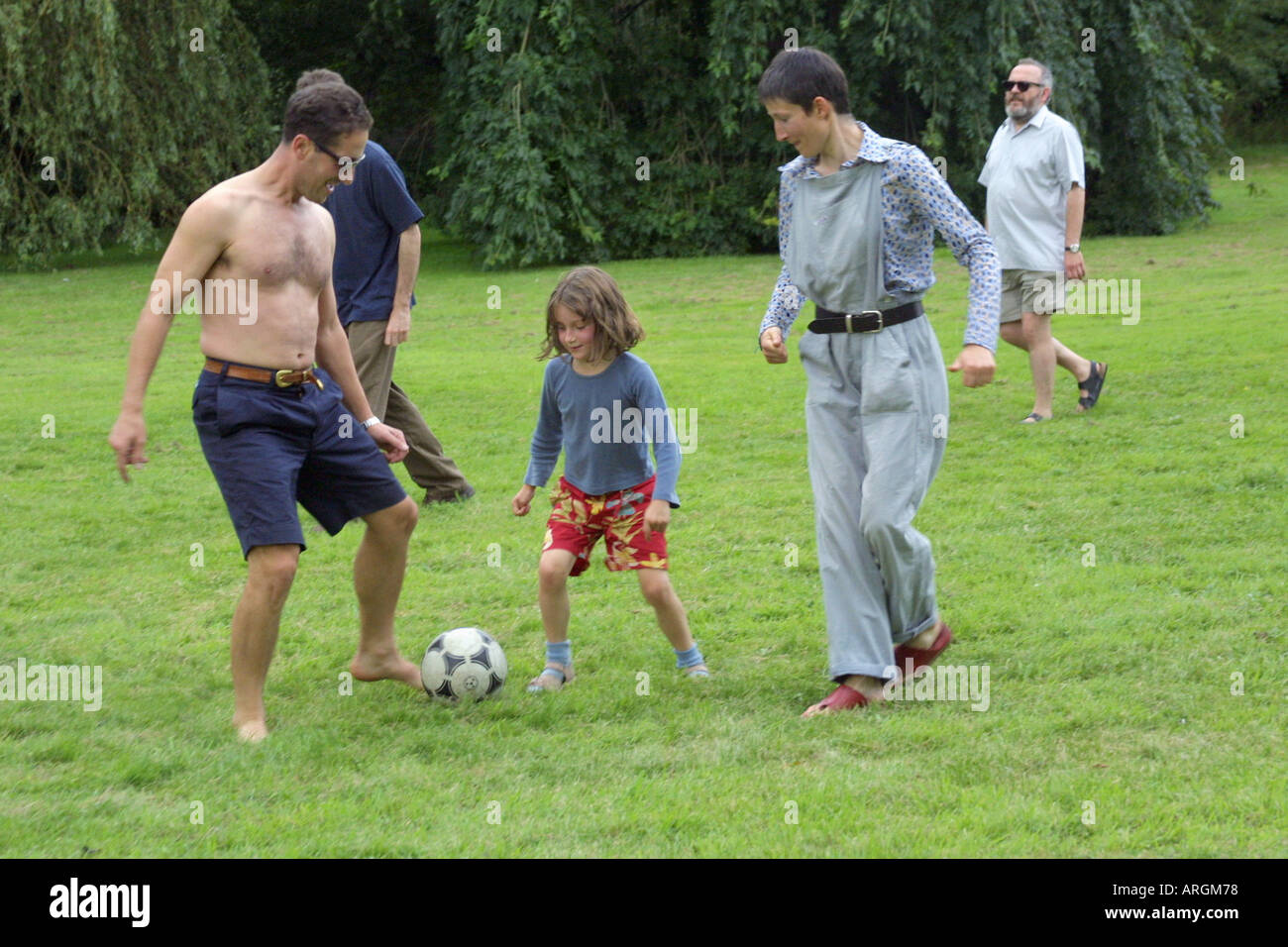 Family playing football in a field Stock Photo - Alamy
