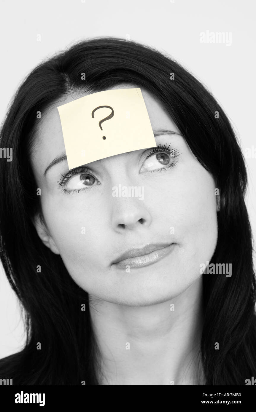 woman with post it note on her forehead looking thoughtful Stock Photo ...