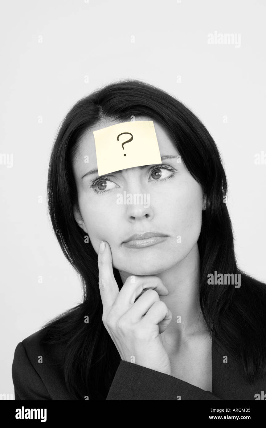 woman with post it note on her forehead looking thoughtful Stock Photo ...