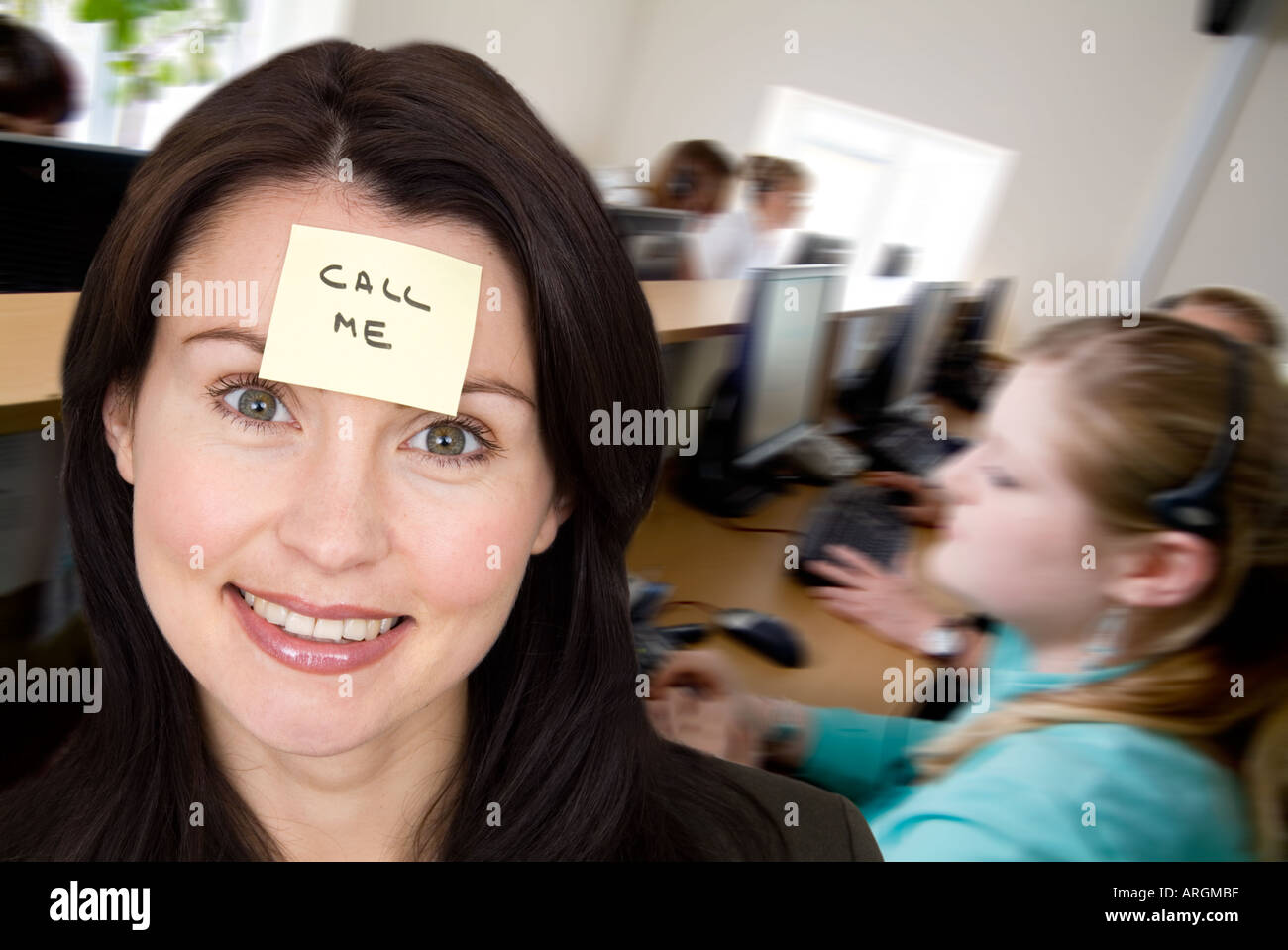 woman with post it note on her head with call me on it in a call center ...