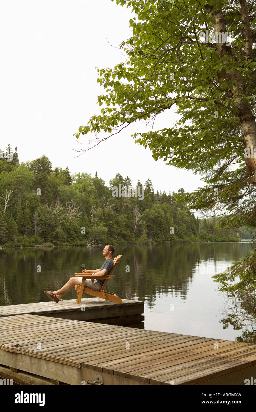 Man Sitting in Chair on Dock Stock Photo - Alamy