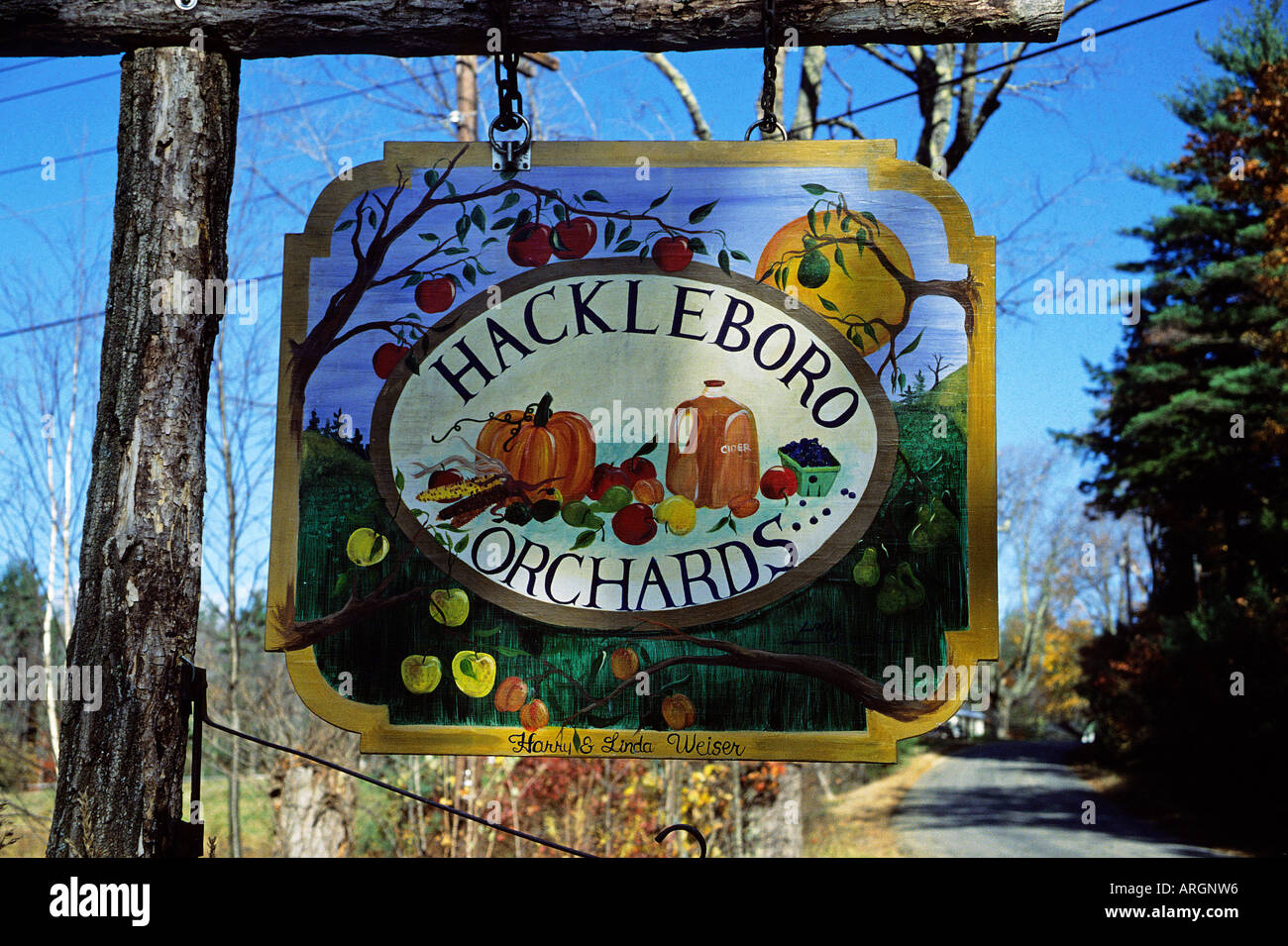 Detail of a painted sign indicating local orchards hanging from a ...