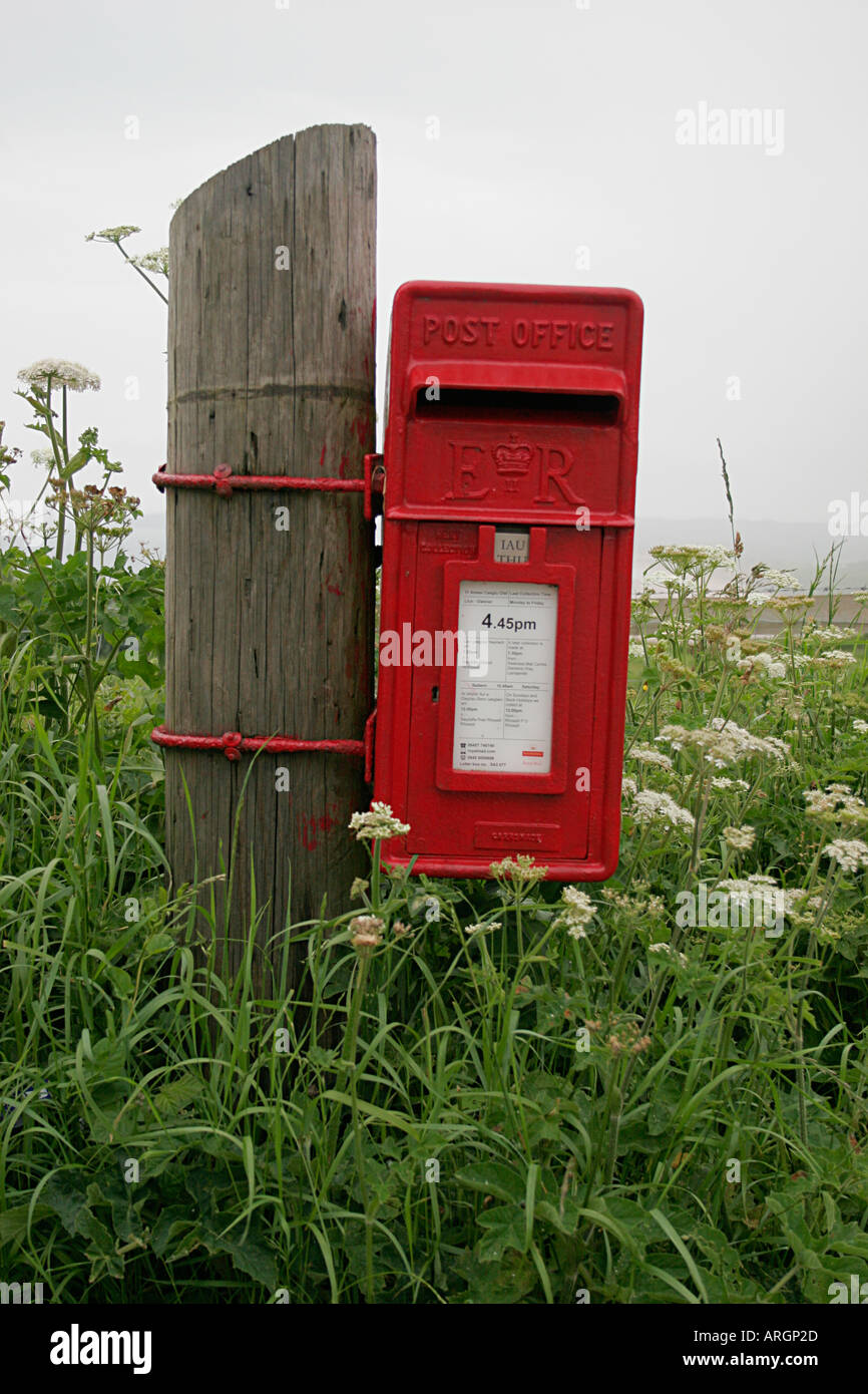 TRADITIONAL RED BRITISH RURAL POSTBOX ATTACHED TO A WOODEN POST AT ...
