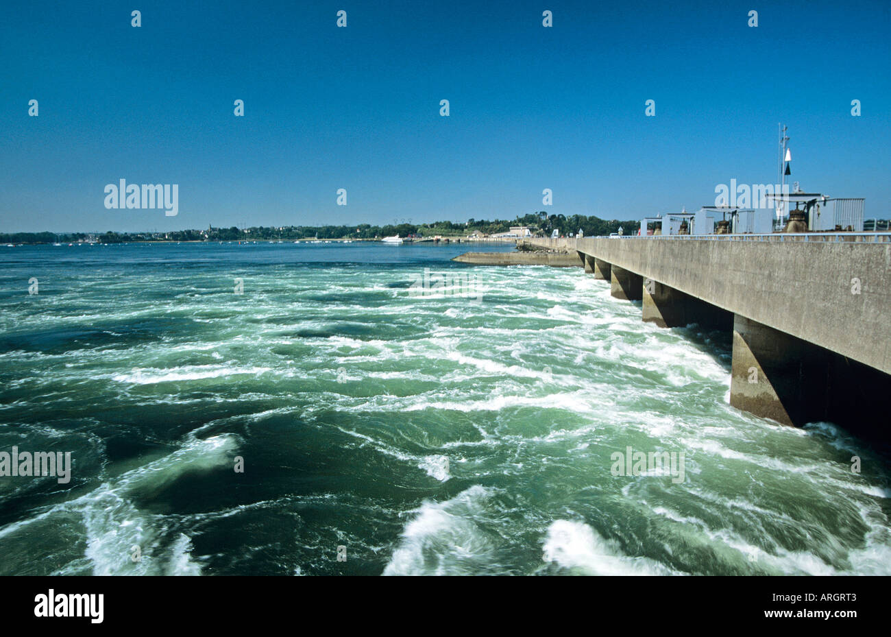 Water surging around the base of the dam alongside the power station ...