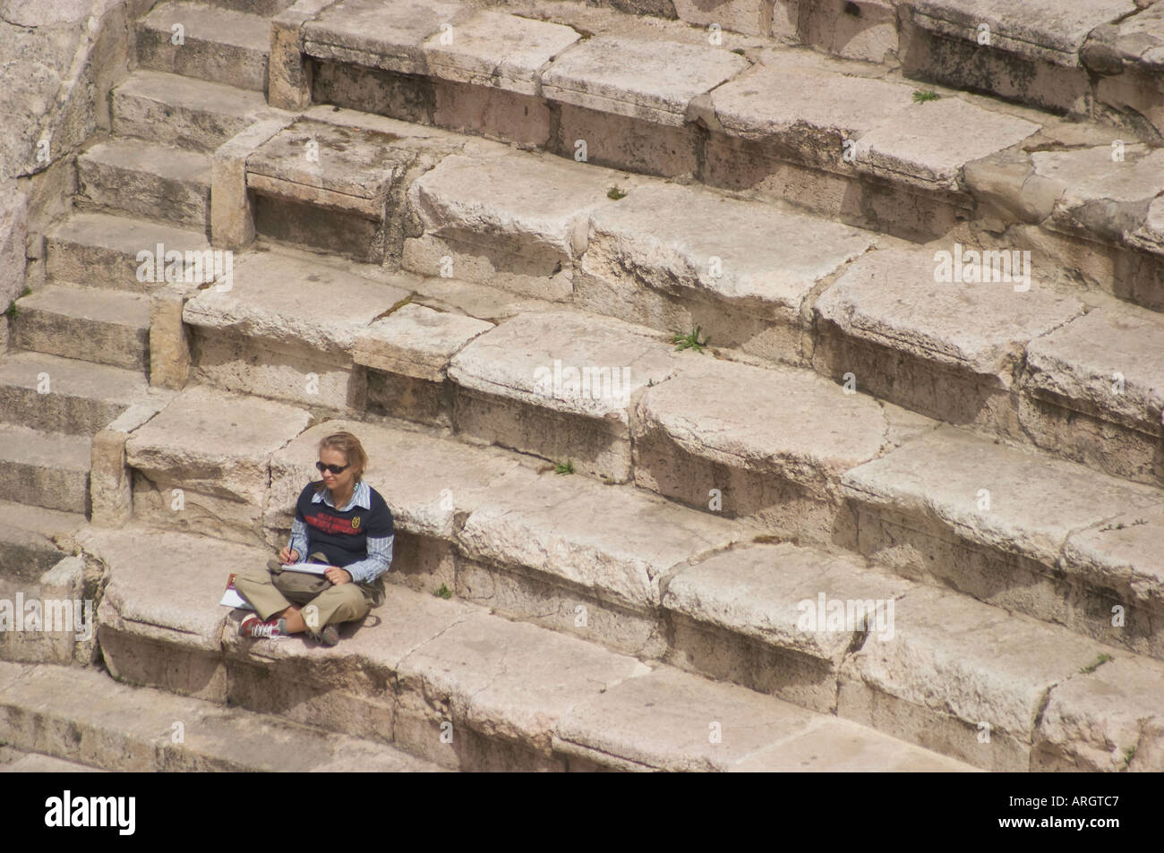 a lady sitting on stairs in The Roman theatre in Amman Jordan Stock ...