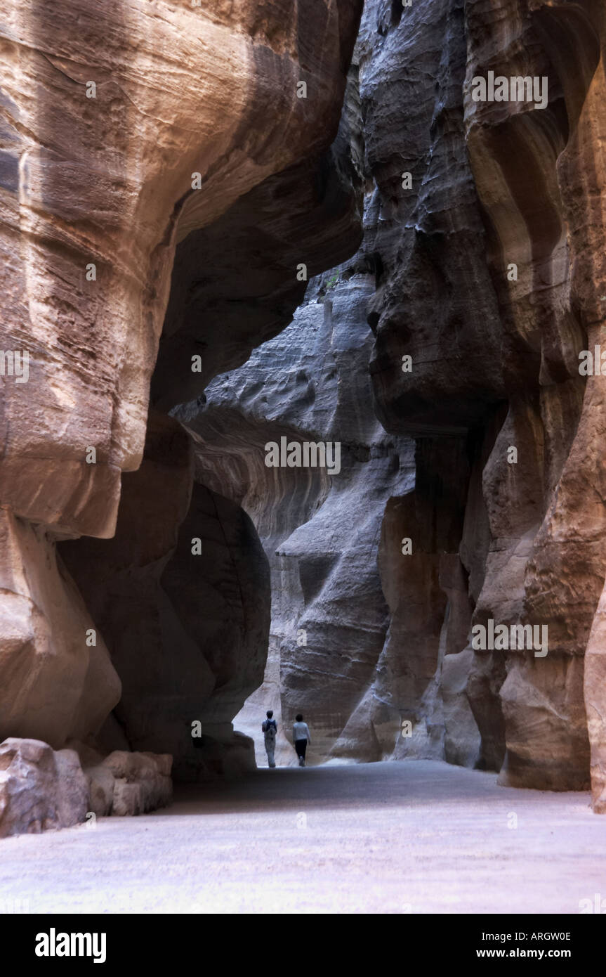 people walking through a mystical Gorge in Petra Jordan. The Siq gorge ...